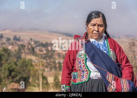 Senior Peruvian female farmer in traditional costume standing in rural ...