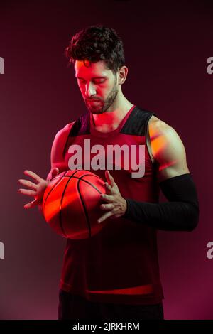 Creative studio shot of basketball player in studio using colored gels ...