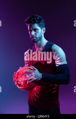 Creative studio shot of basketball player in studio using colored gels ...