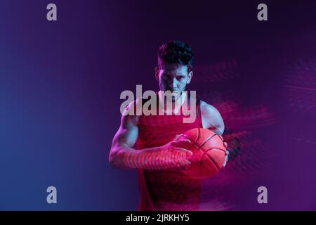 Creative studio shot of basketball player in studio using colored gels ...