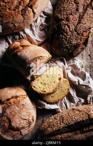 A vertical top view of breads in artisan style plates on wooden table ...