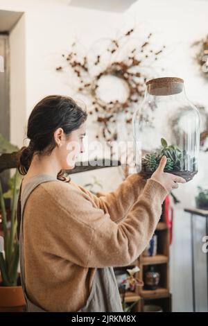 Woman holding big pot with cactus in garden Stock Photo - Alamy