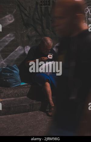 Naples, Italy - July 26, 2022: Portrait of an old man reading a book on ...