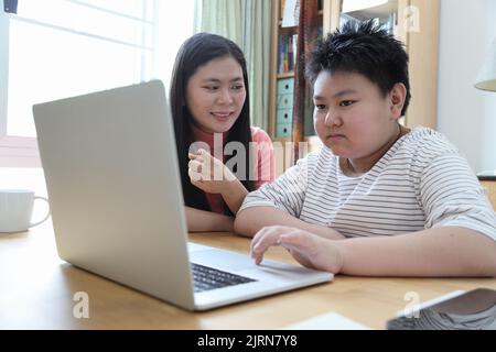 The Asian single mom helping her son to learn from home Stock Photo - Alamy