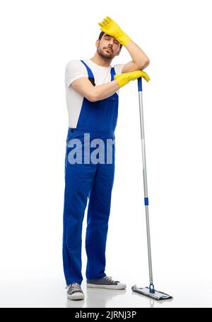 Young cleaner man with blue eyes cleaning wearing apron and gloves ...