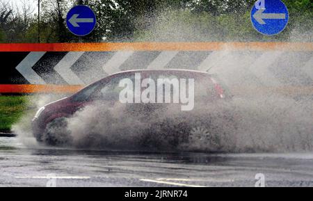 A MOTORIST GETS DRIVES THROUGH FLOODWATER ON A ROUNDABOUT ON THE A27 AT ...