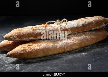 pile of baguette bread loaves tied with rope Stock Photo - Alamy