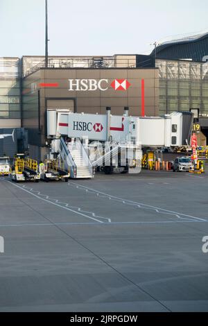 HSBC bank sponsorship adorning airport buildings, jet bridge and sky ...