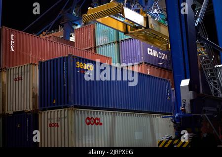 Operation of container terminal at night. Unloading container ship at ...