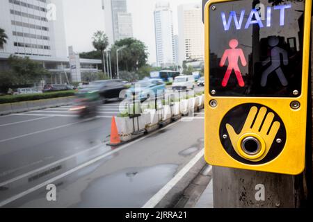 Wait signal sign located at pedestrian crosswalk area on a busy city ...