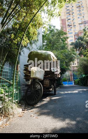A vertical shot of a typical garbage collector bike full of cardboard ...