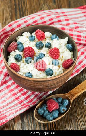 organic cottage cheese on a clay plate, sour cream in a small bowl on ...