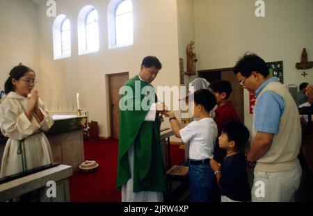 Priest Giving Communion At Korean Mass St Anne's Catholic Church ...