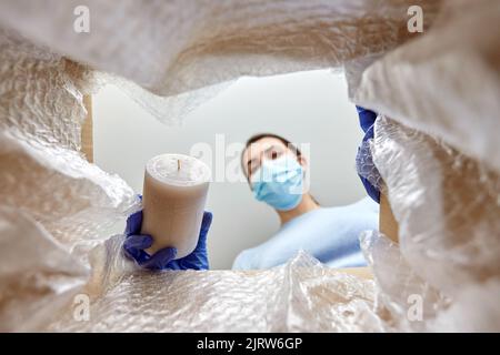 woman in mask packing candles into parcel box Stock Photo - Alamy