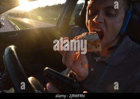 Distracted driving, eating & using phone while driving Stock Photo - Alamy