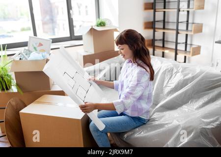 woman with blueprint and boxes moving to new home Stock Photo - Alamy