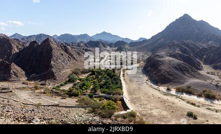 Wadi Shawka Dam panorama, with empty dam, dry riverbed and rocky Hajar ...
