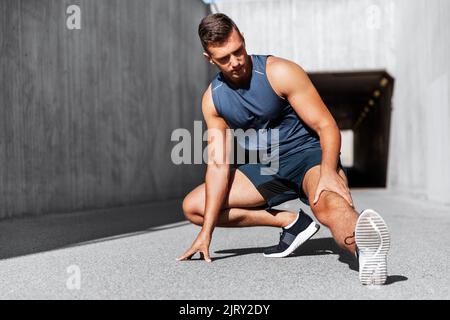 man doing sports and stretching leg outdoors Stock Photo - Alamy