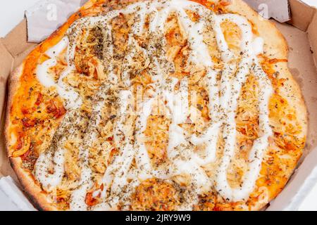 Round chicken pizza with catupiry cheese on a white table. Very common ...