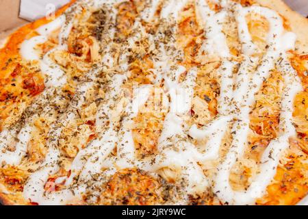 Round chicken pizza with catupiry cheese on a white table. Very common ...