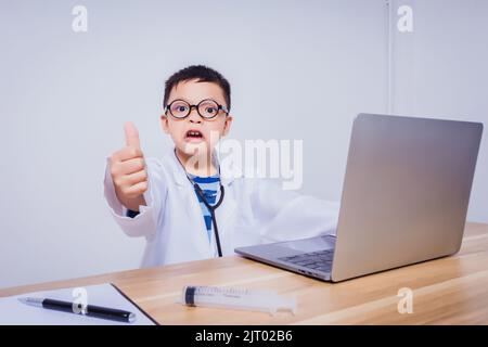 Asian female doctor using laptop computer working on medical documents ...