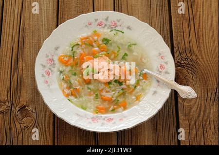 Homemade fish soup with rice and carrot on wooden background horizontal ...