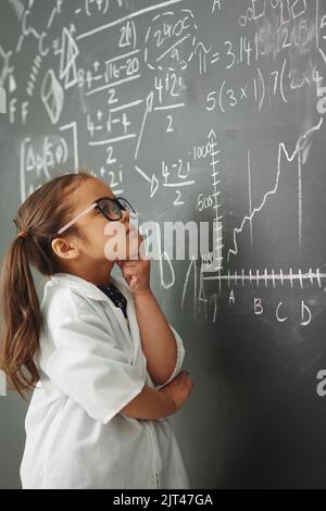 Little genius. Smart little girl math student on school blackboard ...