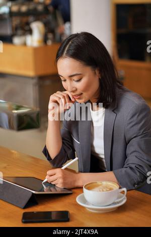 young Asian woman professional writing notes in book at modern office ...