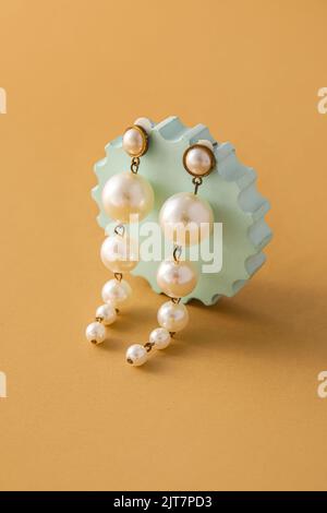 Stylish pearl earrings on beige background Stock Photo - Alamy