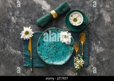 Stylish table setting with beautiful chamomile flowers on grunge ...
