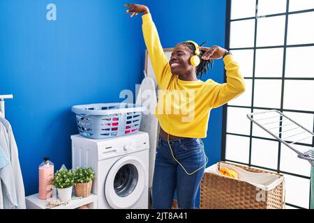 African american woman liatening to music waiting for washing machine ...