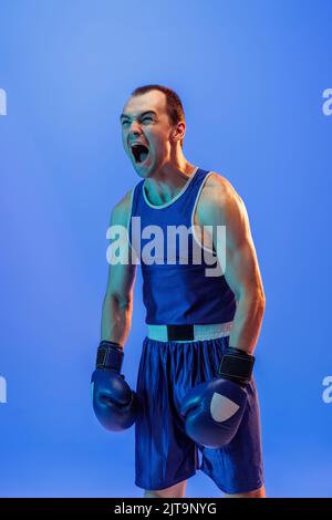 Winner emotions. Male boxer in red uniform and boxing gloves training ...
