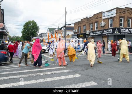 Devout Sikh women and men sweep 101st Avenue where a parade float carry ...