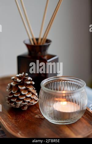 candle holder, reed diffuser and pine cone at home Stock Photo - Alamy