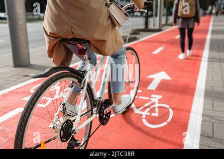 woman cycling behind pedestrian along bike lane Stock Photo - Alamy