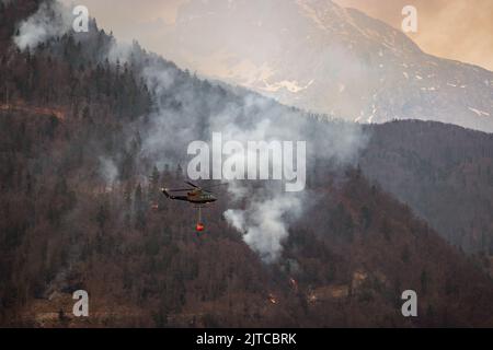 Localized wildfire with the helicopter dropping water by using a water ...
