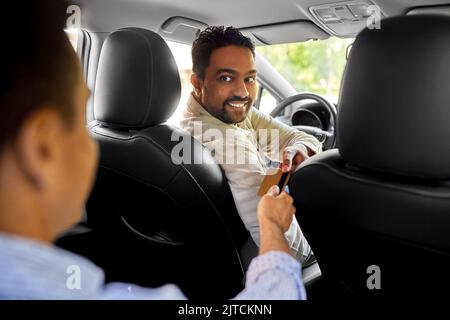 taxi car driver taking credit card from passenger Stock Photo - Alamy