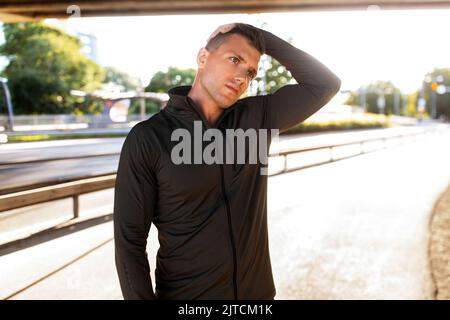 man stretching neck under bridge Stock Photo - Alamy