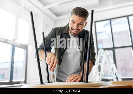 happy man assembling coffee table at new home Stock Photo - Alamy