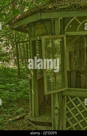 Summer cloudy day. There is an old dilapidated summer gazebo in the ...