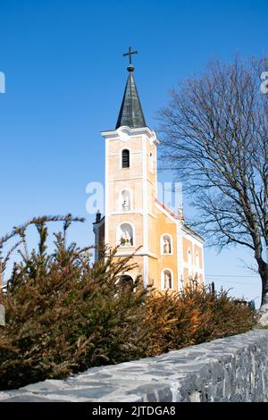 Small church with white walls and a brown roof under bright sunlight ...