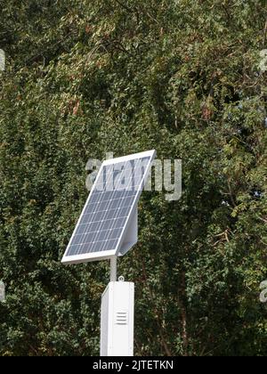 Portable solar panel connected to light bulb isolated on white ...