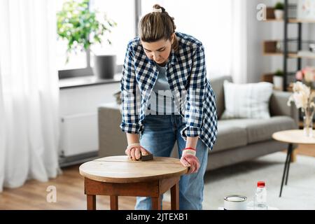 woman sanding old round wooden table with sponge Stock Photo - Alamy