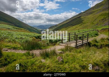 Footbridge path across Glenderaterra Beck at the head of valley between ...