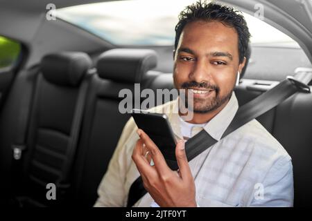 passenger with earphones and cellphone in taxi car Stock Photo - Alamy