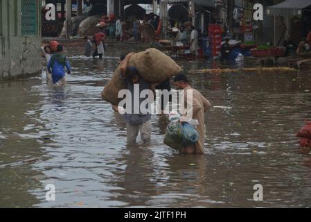 Pakistani people on their way and busy in Badami bagh vegetable market during heavy monsoon ...