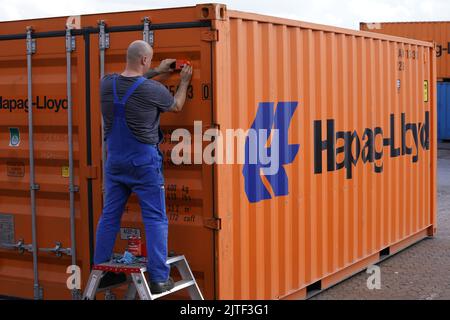 30 August 2022, Hamburg: An employee holds a live tracking device in front of a Hapag-Lloyd ...