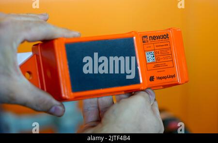 30 August 2022, Hamburg: An employee attaches a live tracking device to ...
