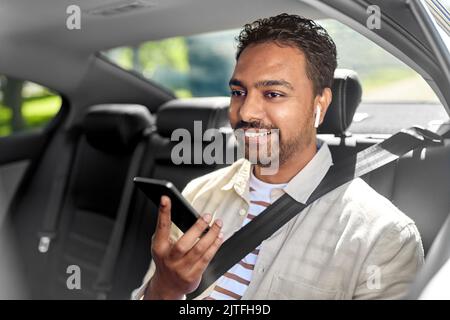 passenger with earphones and cellphone in taxi car Stock Photo - Alamy