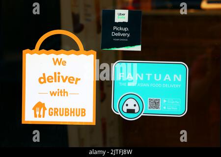 Grubhub, and Uber Eats food delivery services app stickers on a window ...
